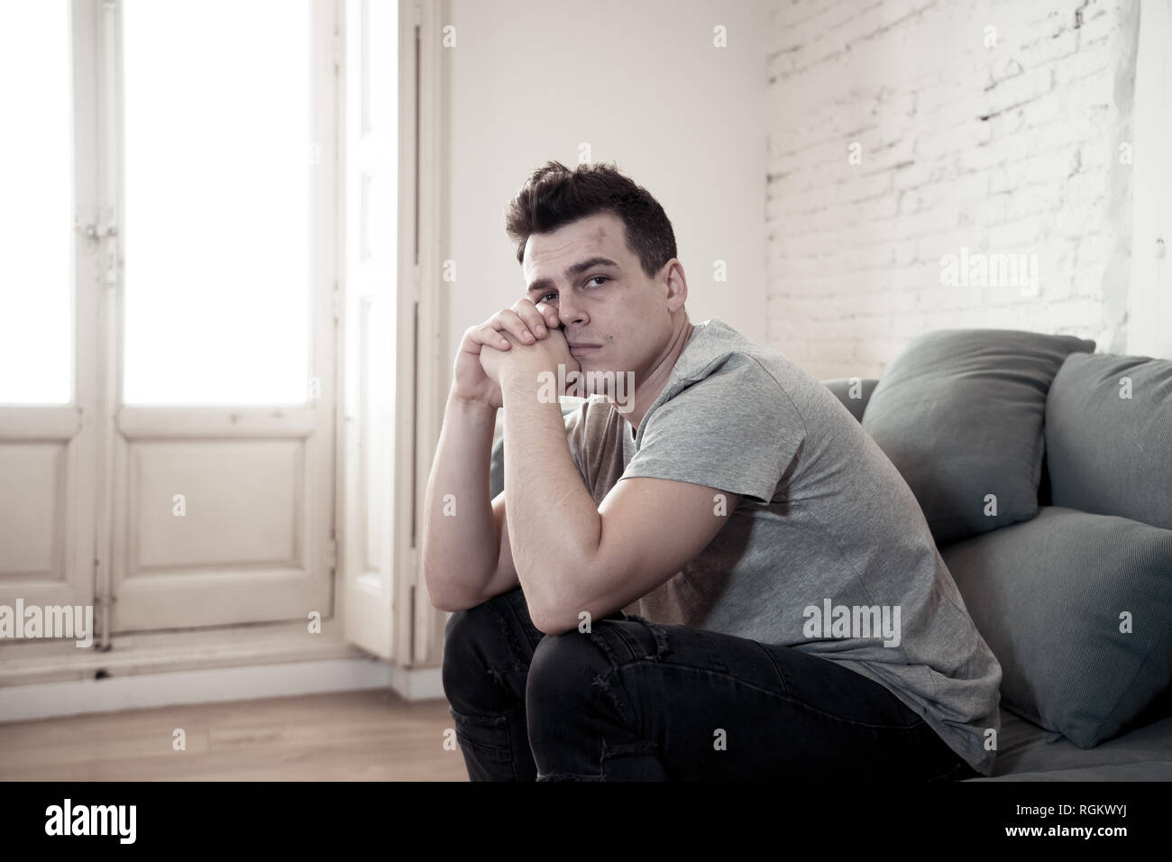 Portrait of young man felling depressed and desperate crying alone in ...