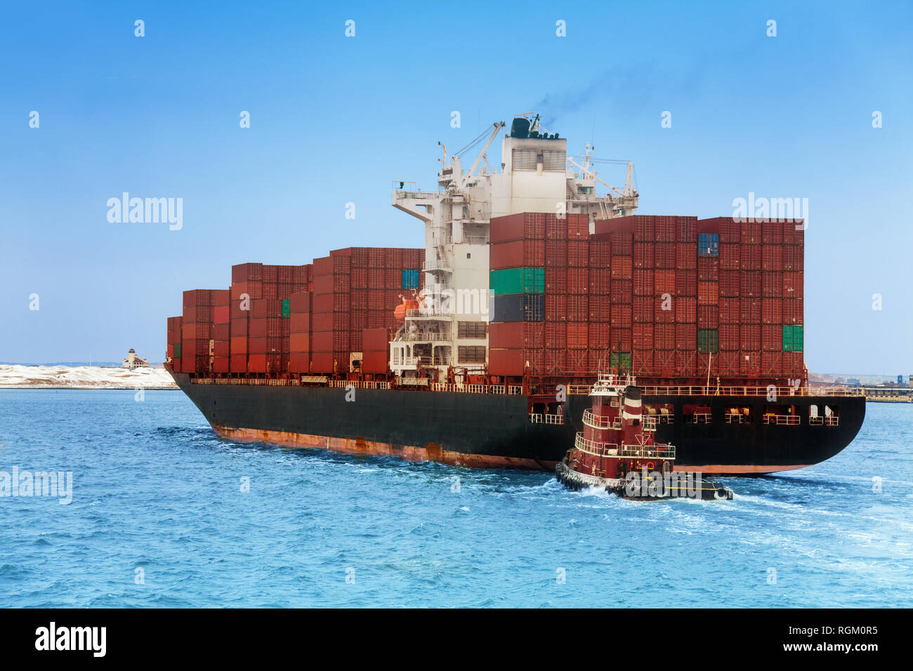 Tug boat and import export dry cargo ship Stock Photo - Alamy