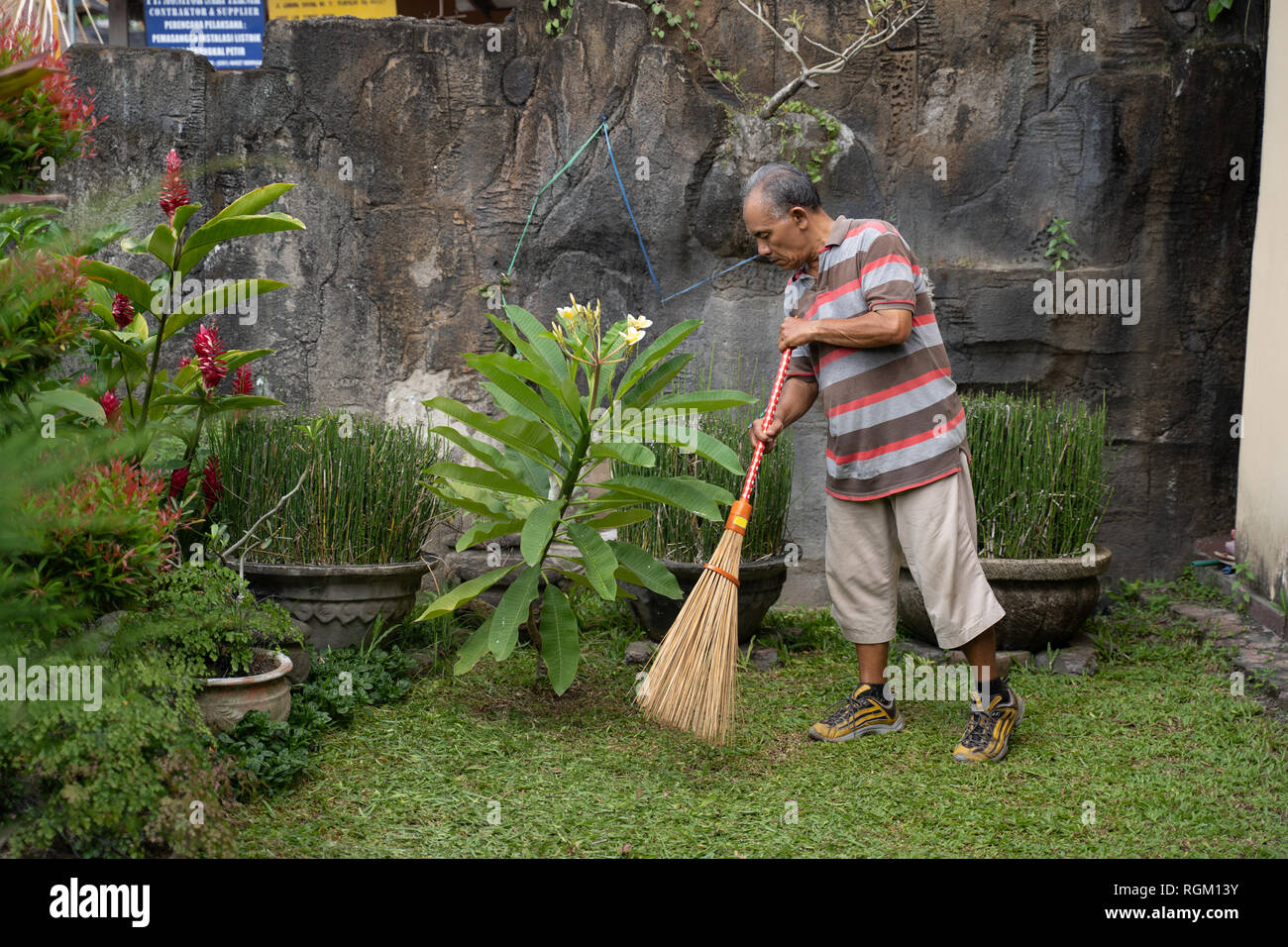 senior asian male sweeping his garden Stock Photo - Alamy