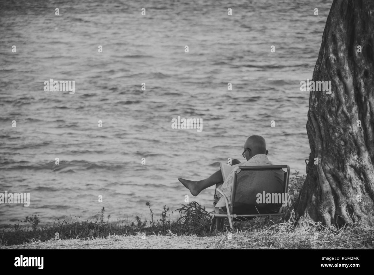 Man sitting at the beach in a folding chair hi-res stock photography ...