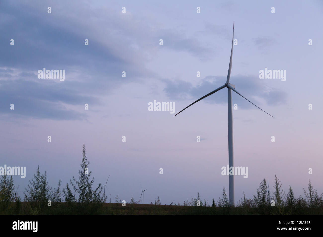 One windmill turbine at blue and purple cloudy sunset sky Stock Photo ...