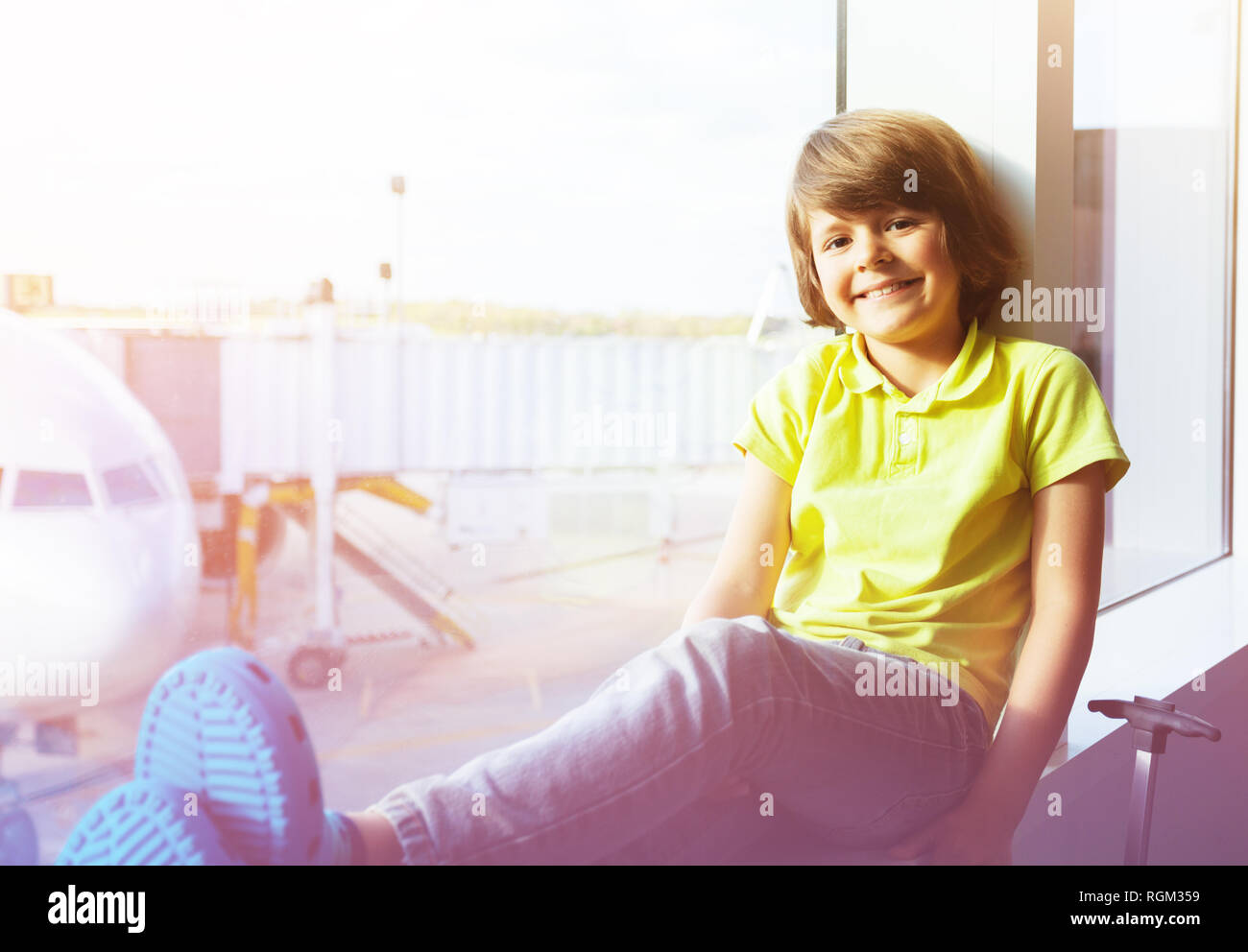 Boy sitting next to window and looking at airplane Stock Photo - Alamy