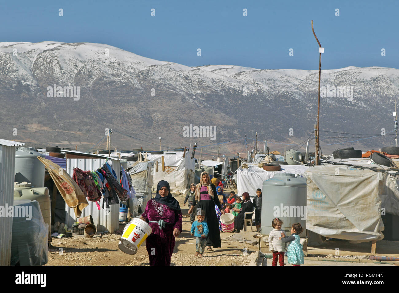 Al Marj, Lebanon. 30th Jan, 2019. Syrian refugees walk between the tents of Al Marj refugee camp ...