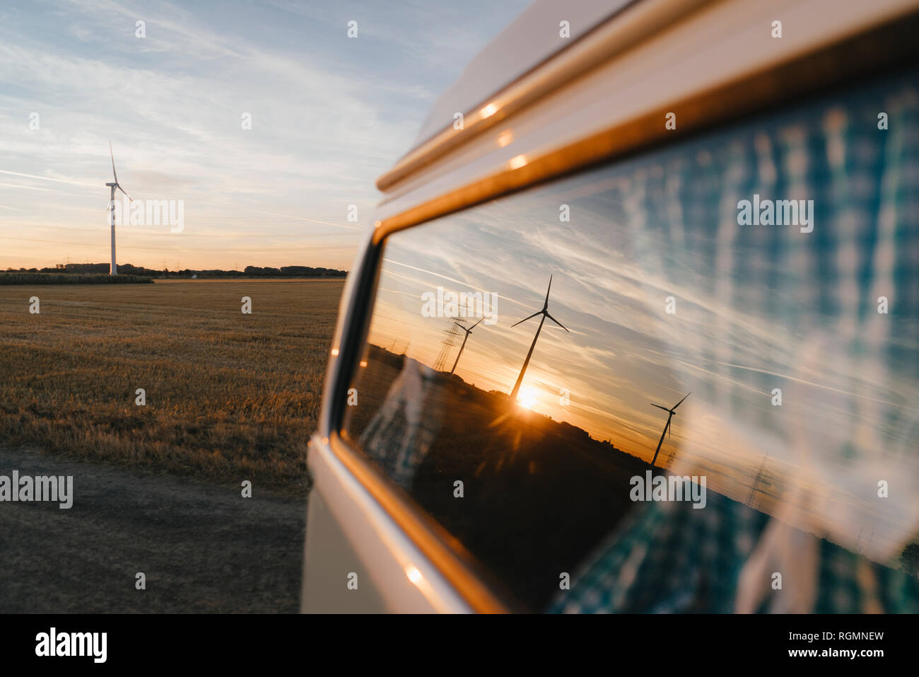 Camper van in rural landscape with wind turbines at sunset Stock Photo ...