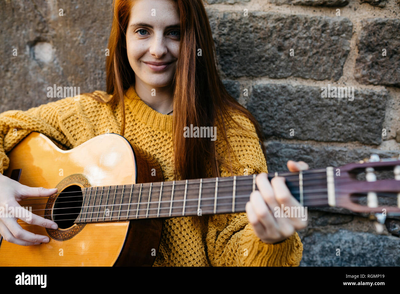 Red haired woman playing guitar city hi-res stock photography and ...