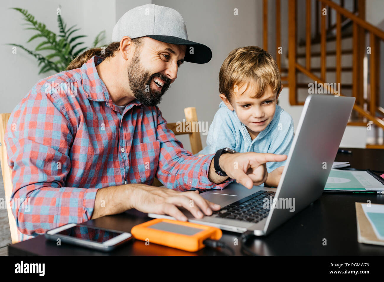 Father and son using laptop together Stock Photo - Alamy