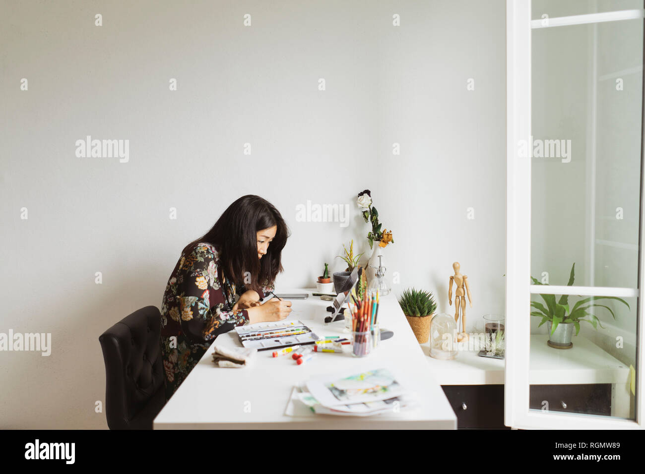 Illustrator at work desk in an atelier using digital tablet for ...