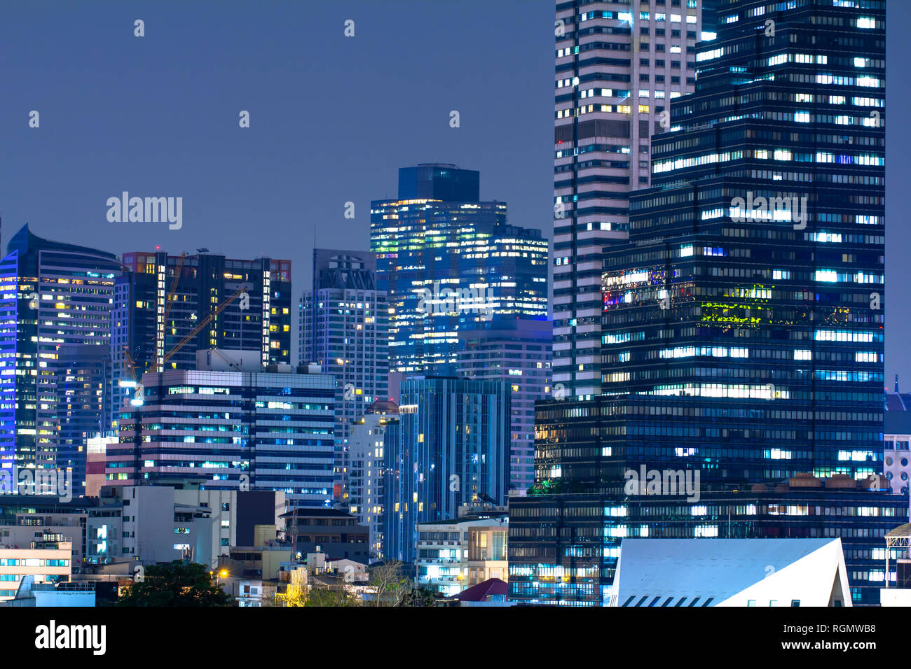 High-rise buildings with electric light in an urban cityscape in blue ...