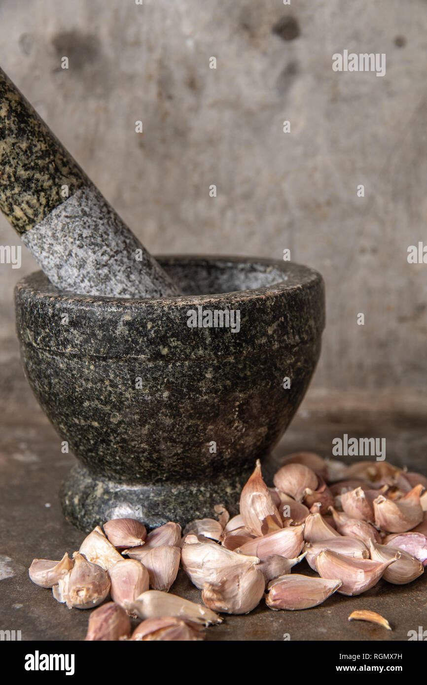 Garlic with stone mortar on top of cement table Stock Photo - Alamy