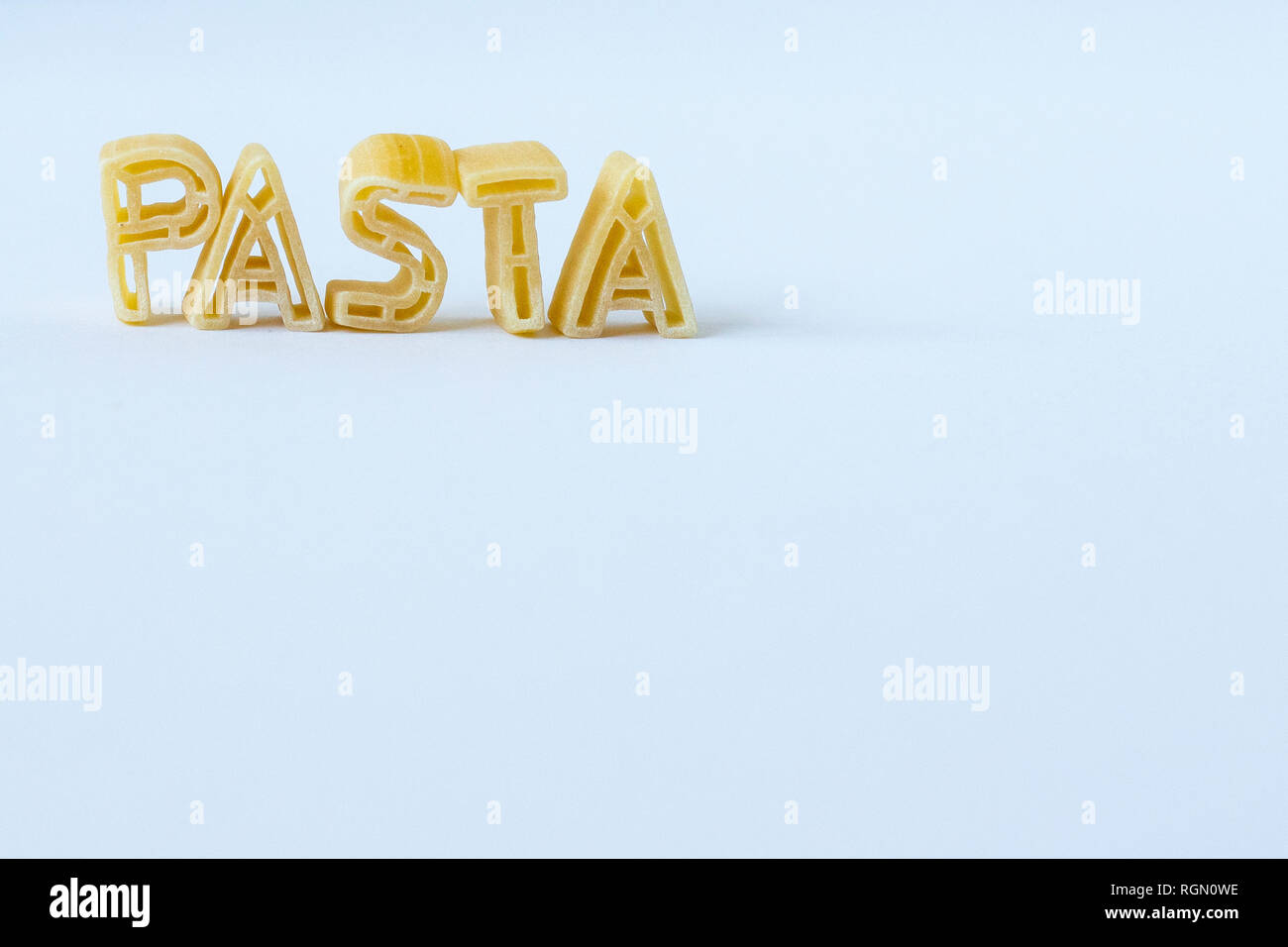 The word "pasta" composed with real pasta letters standing on a white ...