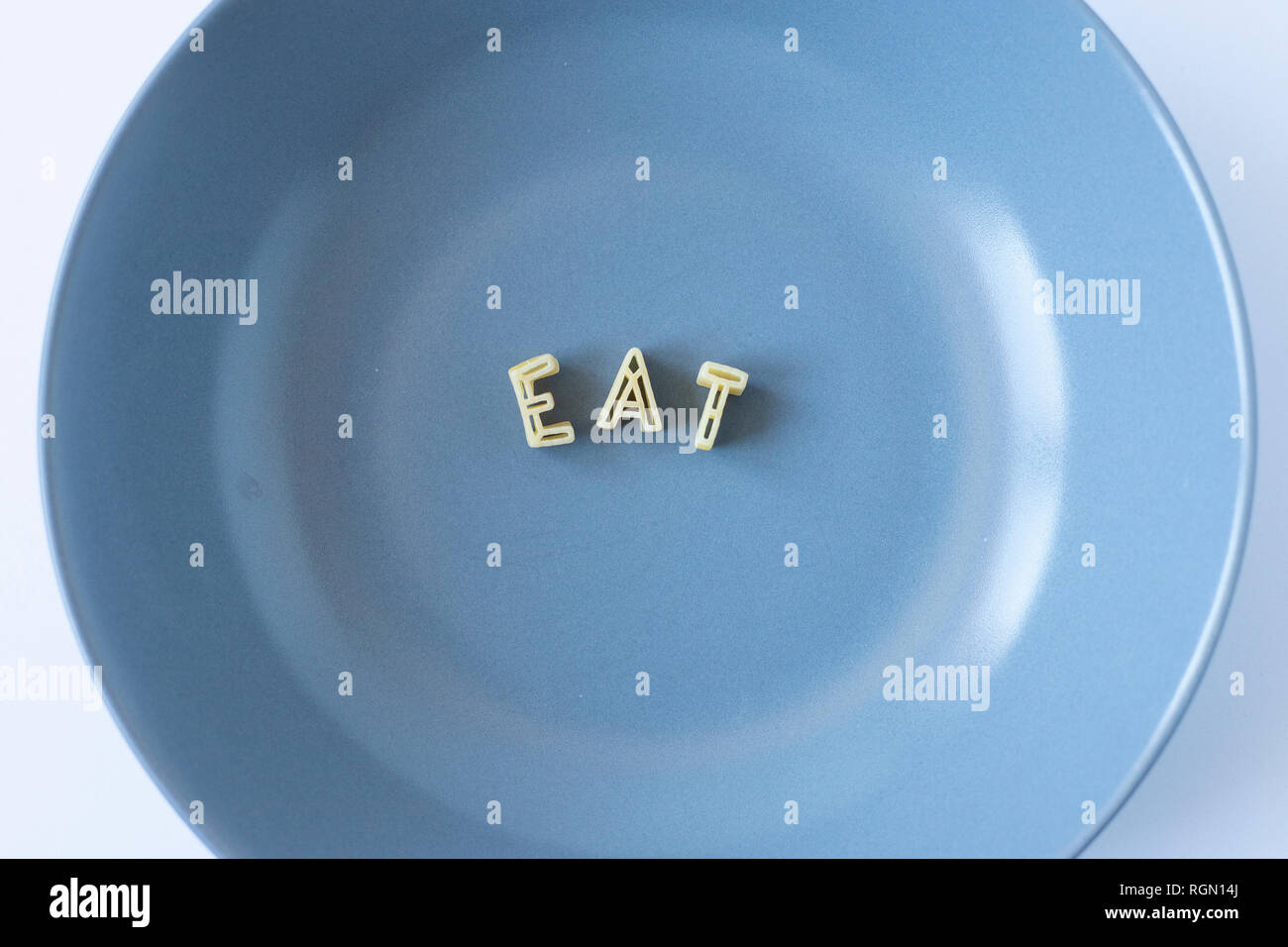The word "eat" composed with real pasta letters in a blue dish Stock ...