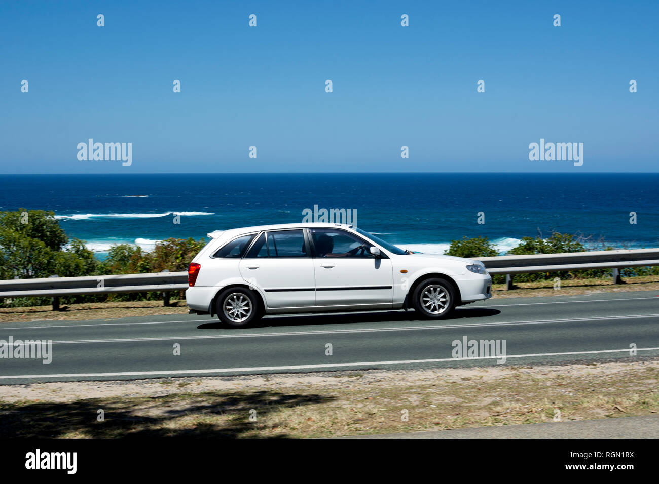 A white car on a coastal road, Point Lookout, North Stradbroke Island ...