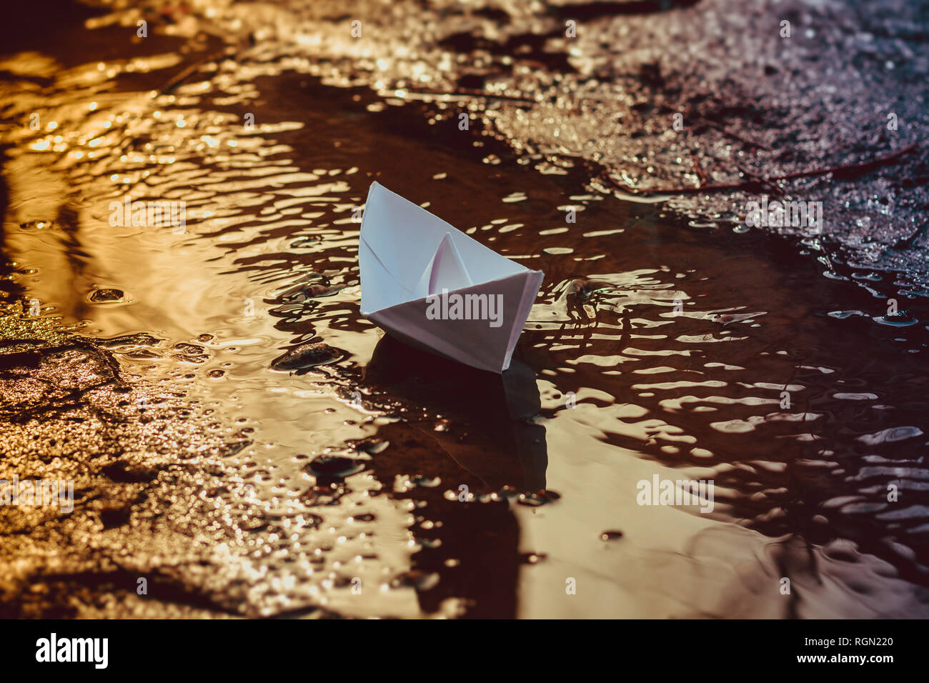 The paper boat floats through the spring puddles. Children's ...