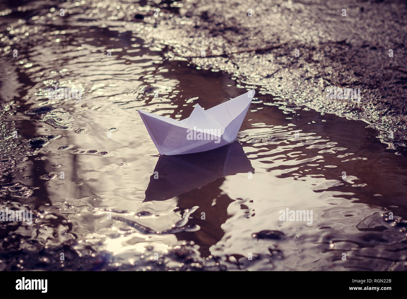 The paper boat floats through the spring puddles. Children's ...