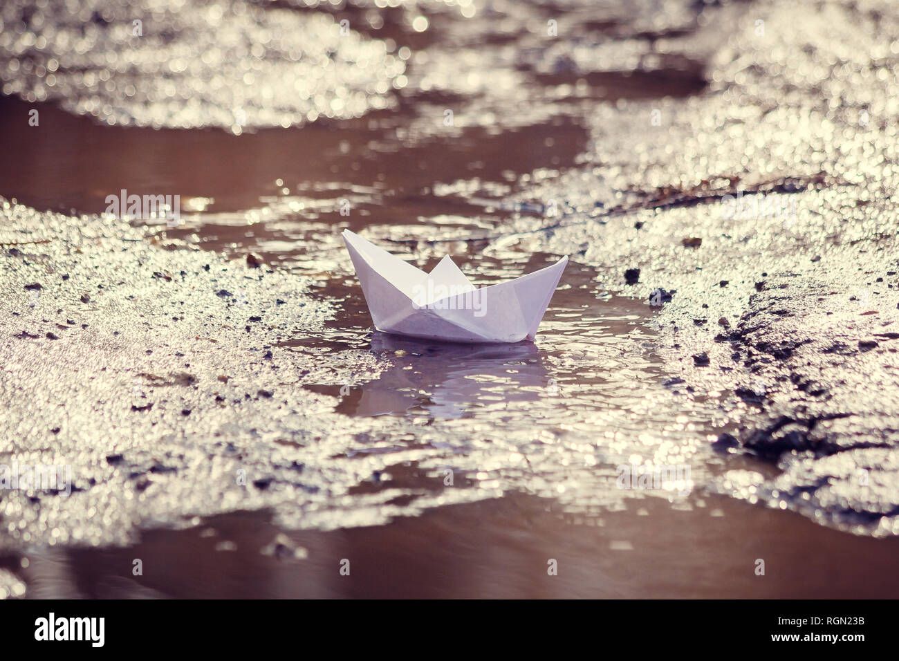 The paper boat floats through the spring puddles. Children's ...