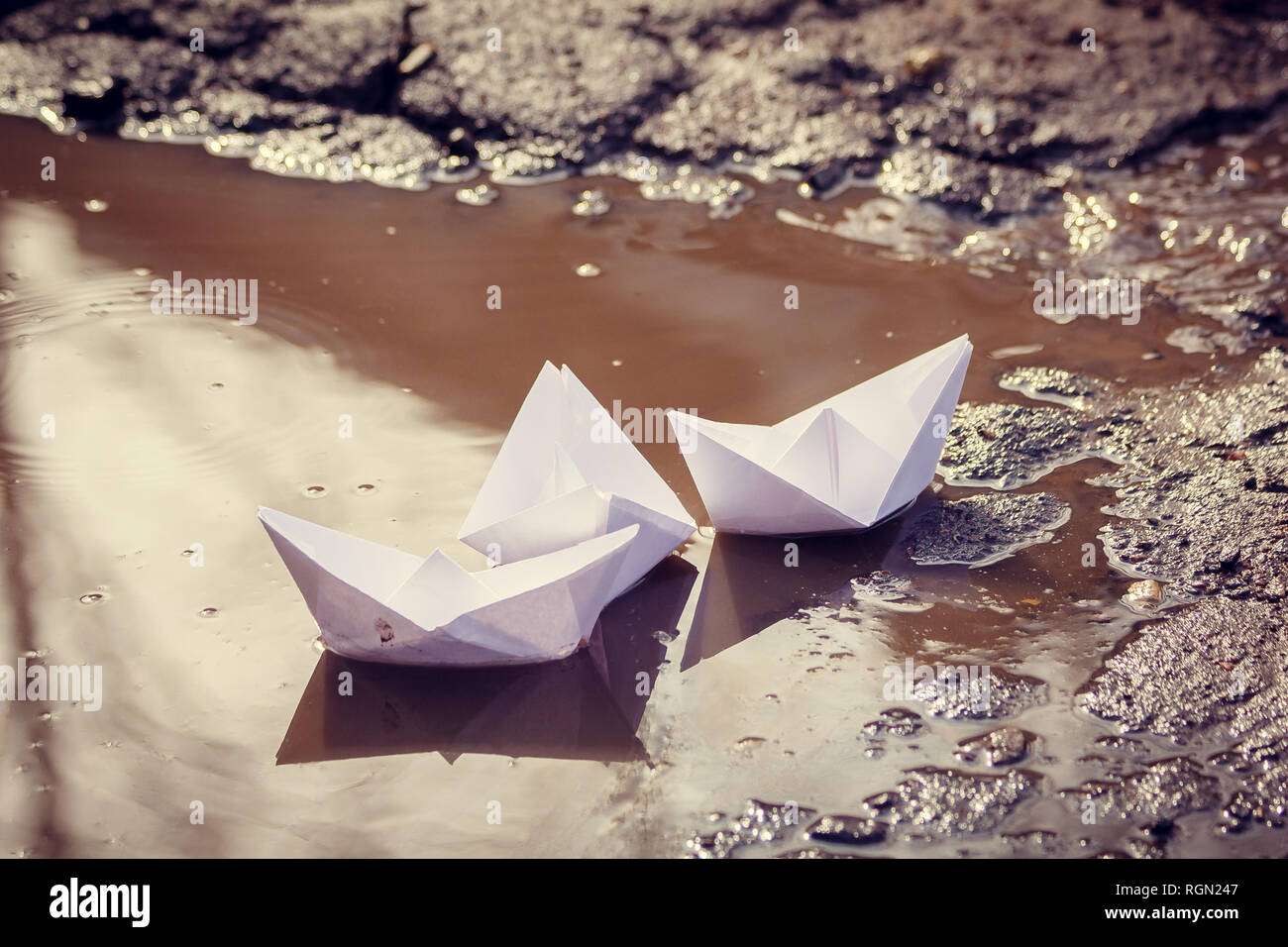 The paper boat floats through the spring puddles. Children's ...