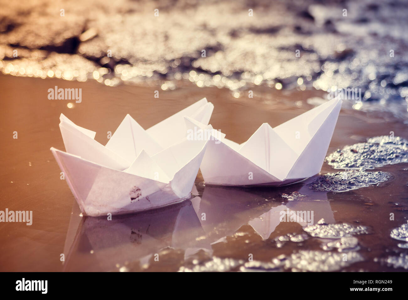 The paper boat floats through the spring puddles. Children's ...