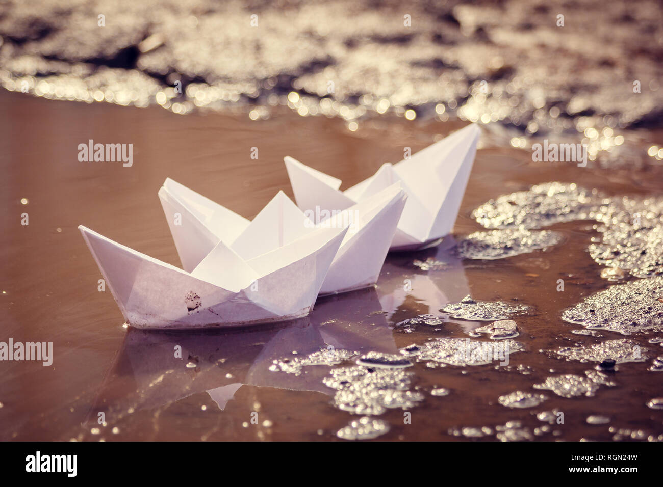 The paper boat floats through the spring puddles. Children's ...