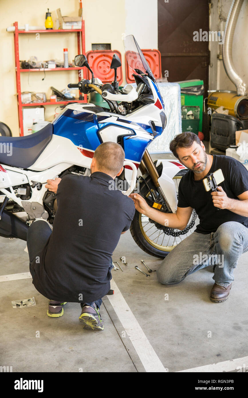 Mechanic working motorcycle workshop filmed partner hi-res stock ...