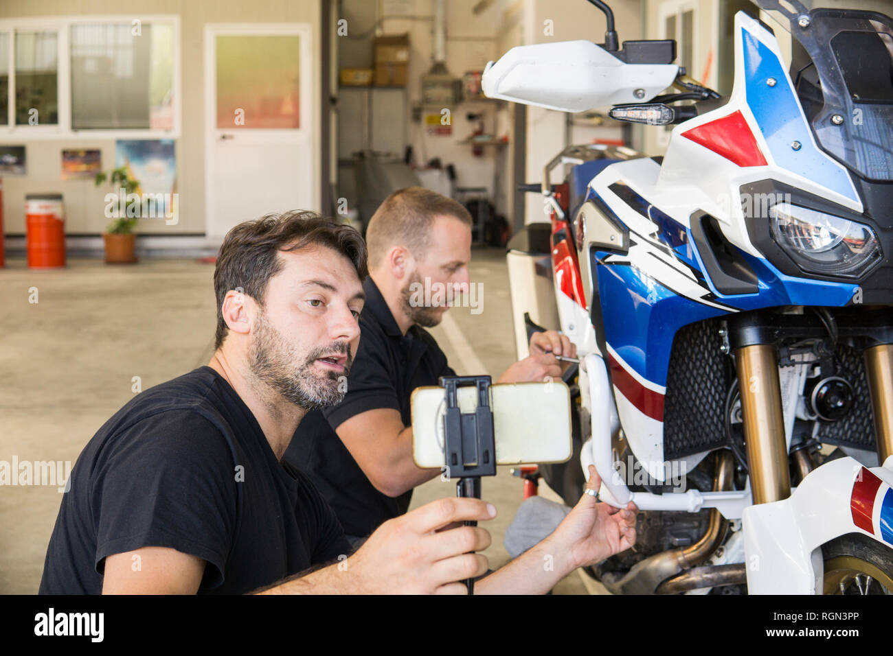Mechanic working motorcycle workshop filmed partner hi-res stock ...