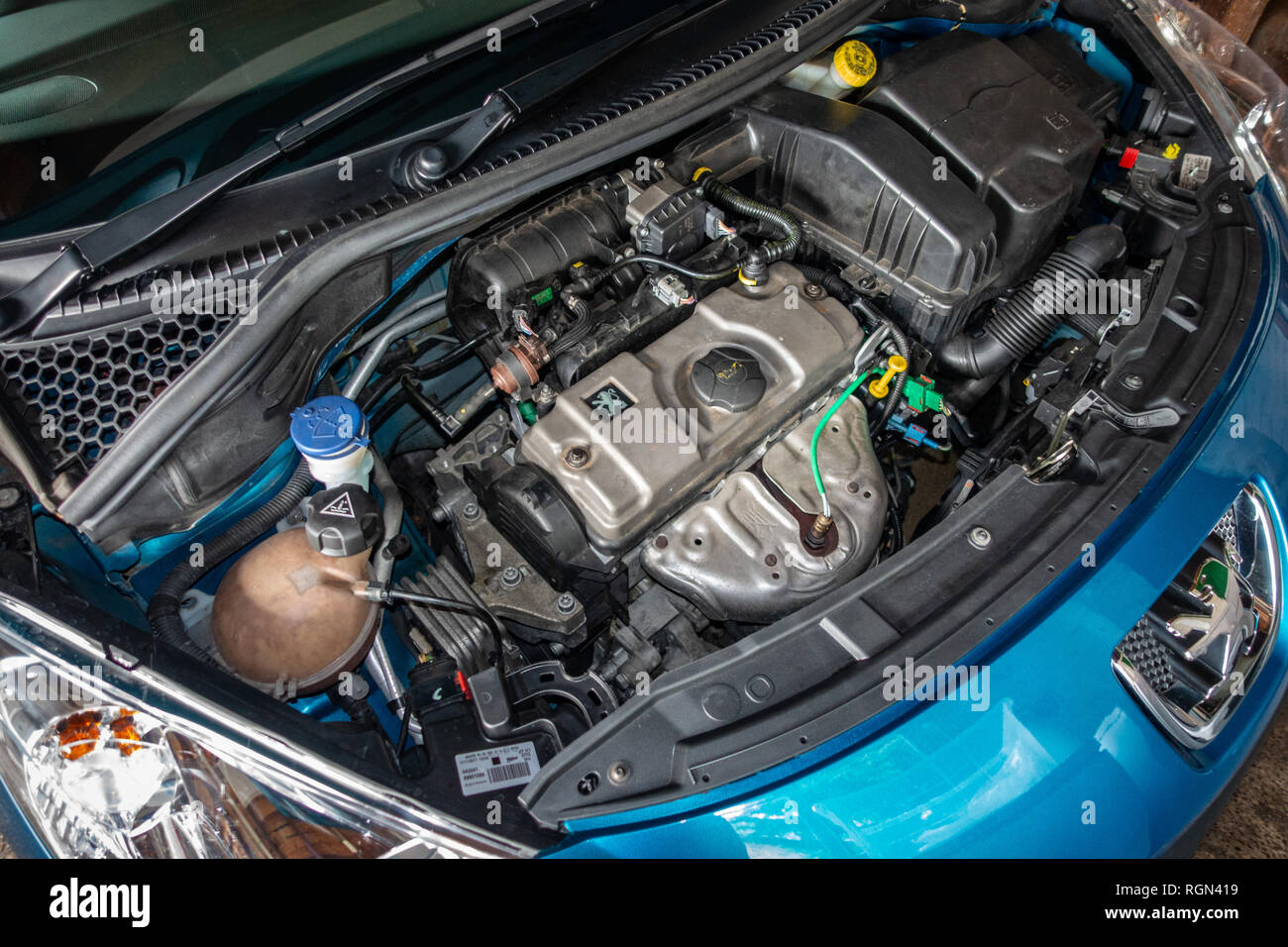 The open bonnet hood showing a Peugeot 207 car engine in England Stock ...