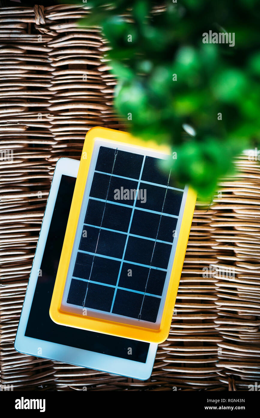 Solar panel charger, tablet and a plant Stock Photo - Alamy