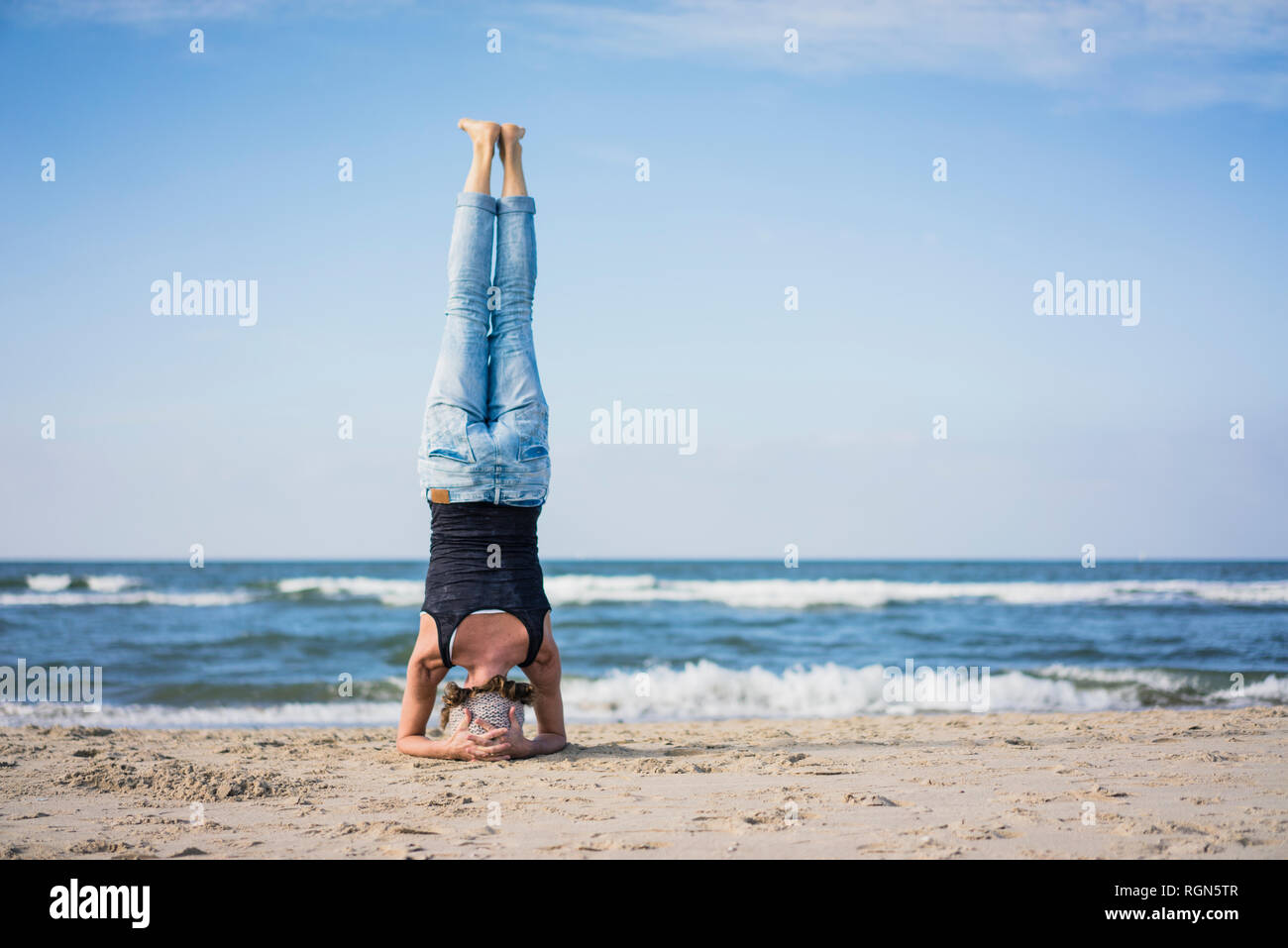 Woman doing headstand on beach hi-res stock photography and images - Alamy