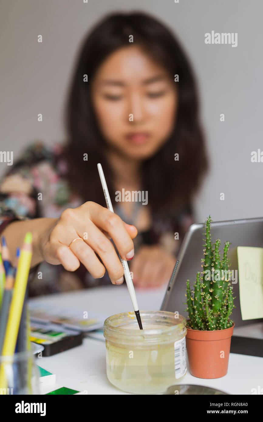 Illustrator painting at work desk in an atelier, close-up Stock Photo ...