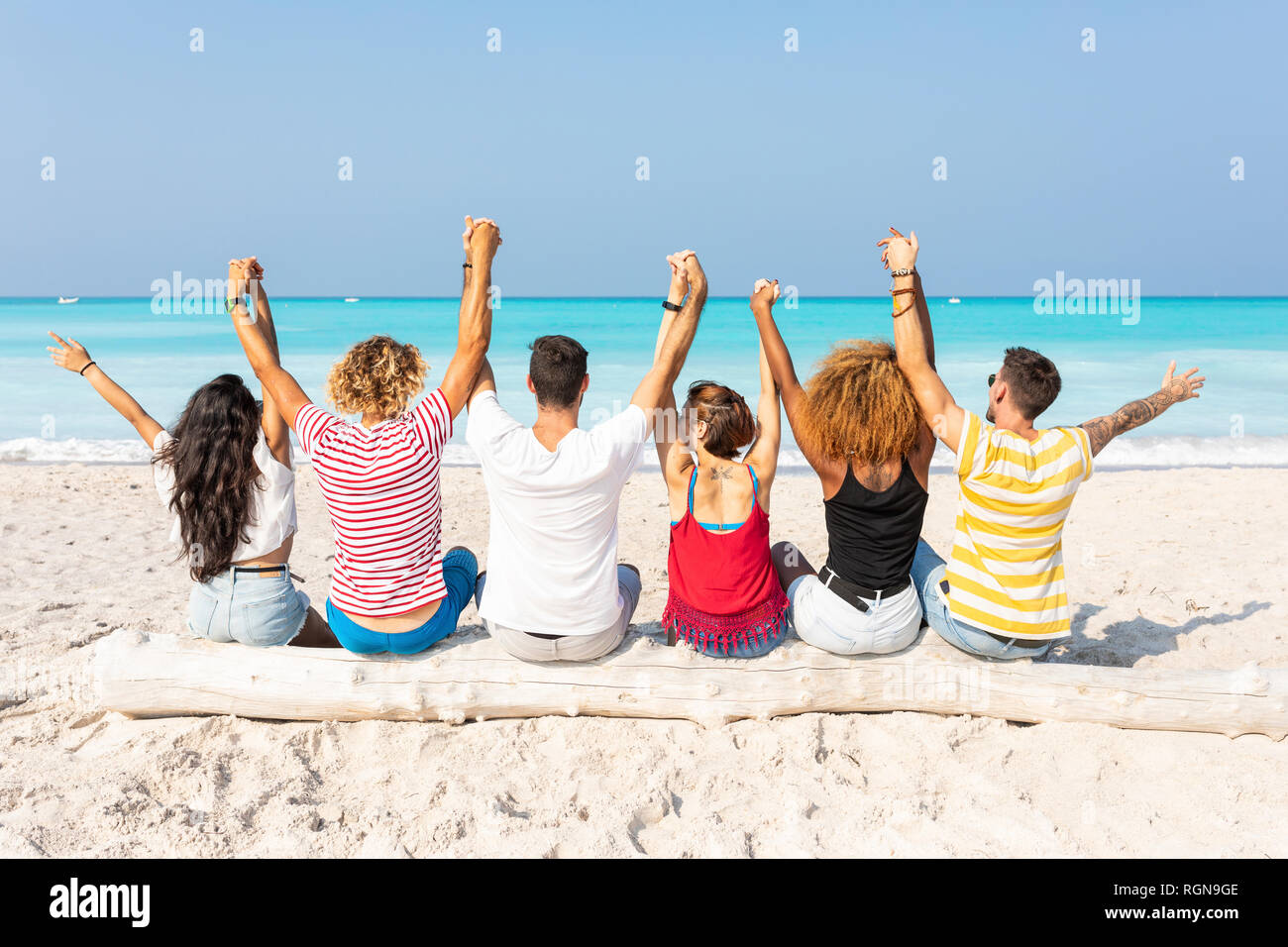 Friends taking a break, sitting on the beach Stock Photo - Alamy