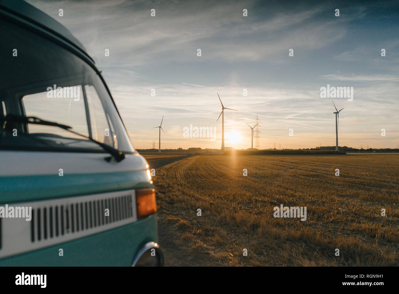 Camper van in rural landscape with wind turbines at sunset Stock Photo ...