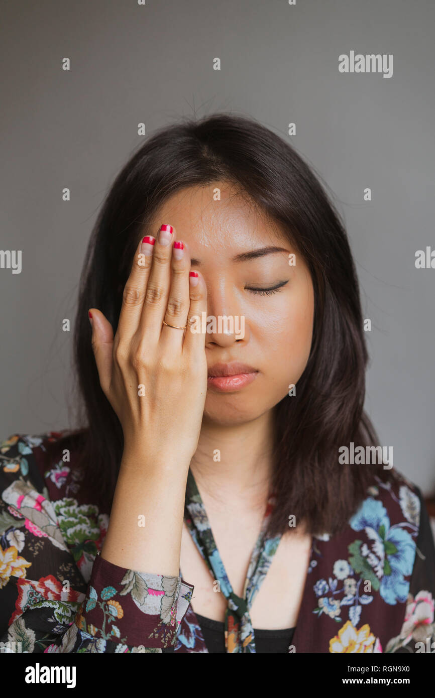 Portrait of woman covering eye with her hand Stock Photo - Alamy