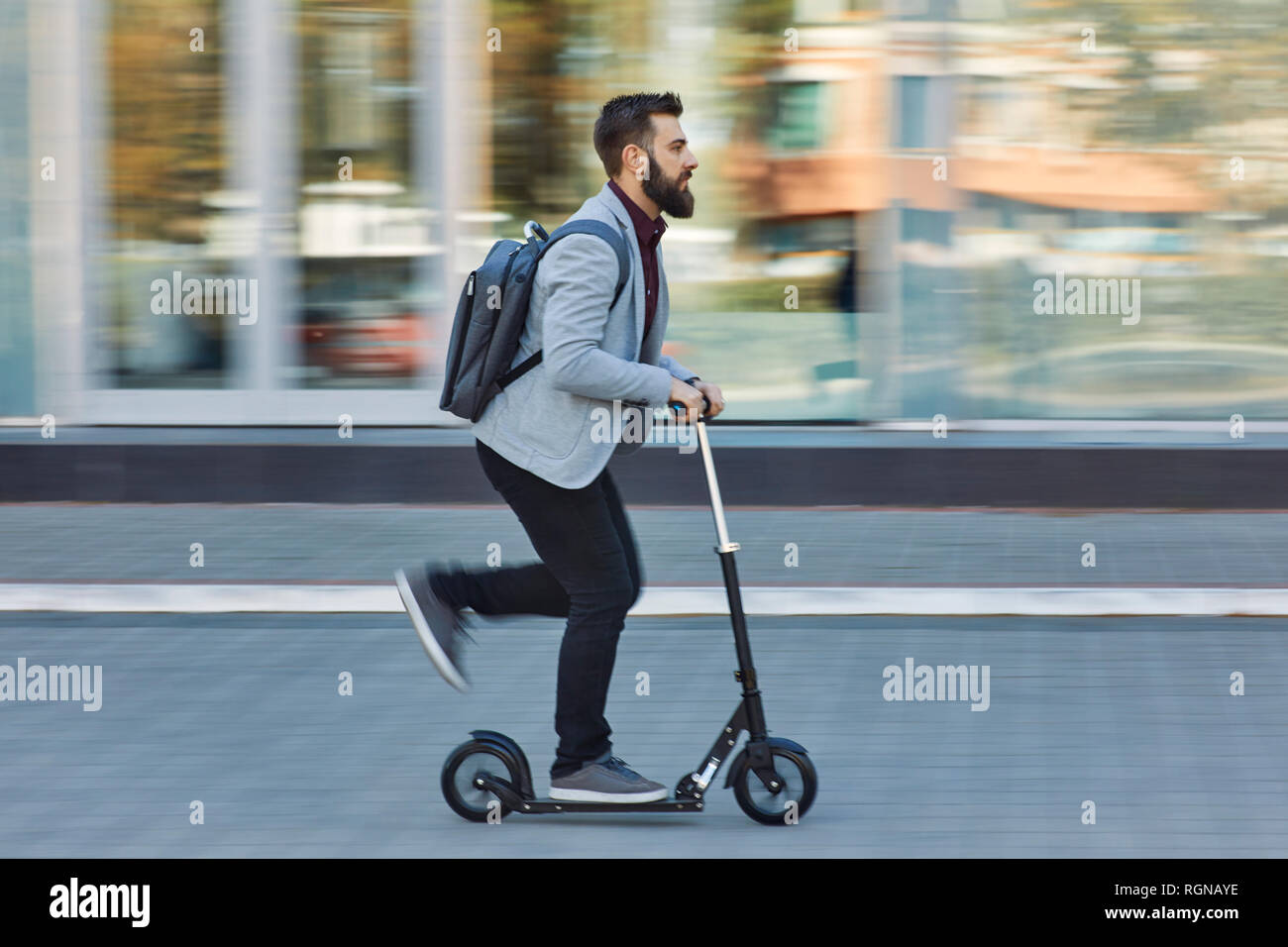 Businessman riding scooter along office building hi-res stock ...