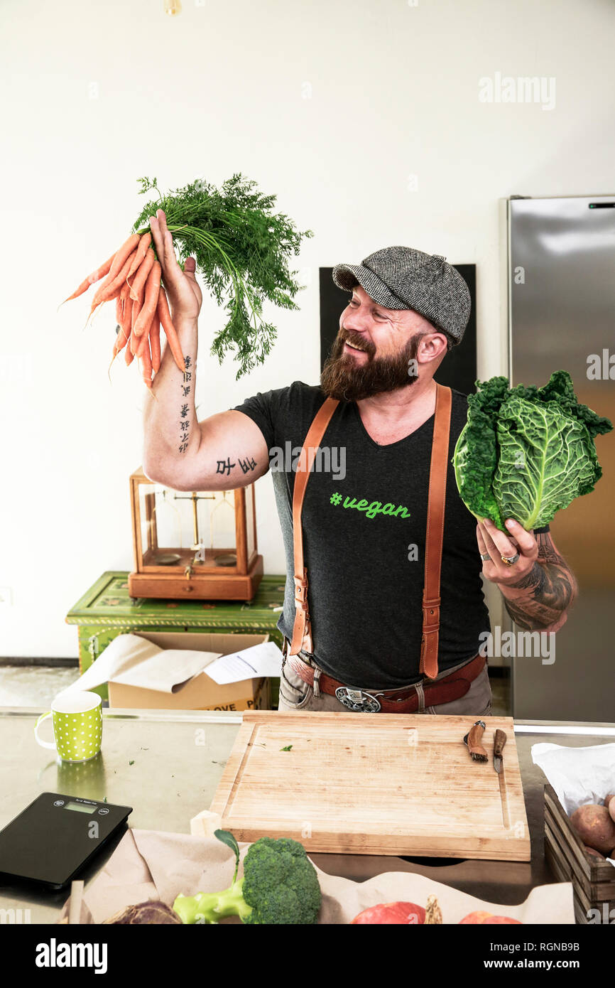 Vegan man choosing vegetables in his kitchen Stock Photo - Alamy