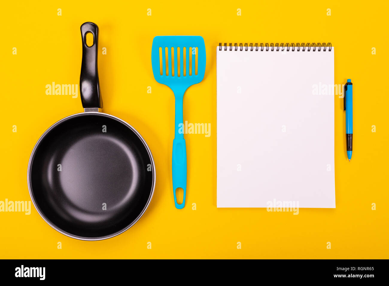 Kitchen utensils and clean sheet of paper isolated on yellow background ...