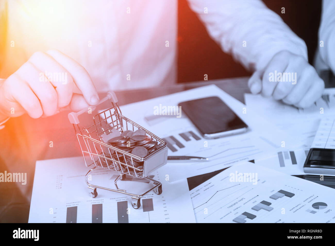 man's hand holds a Dummy shopping cart filled with coins Stock Photo ...