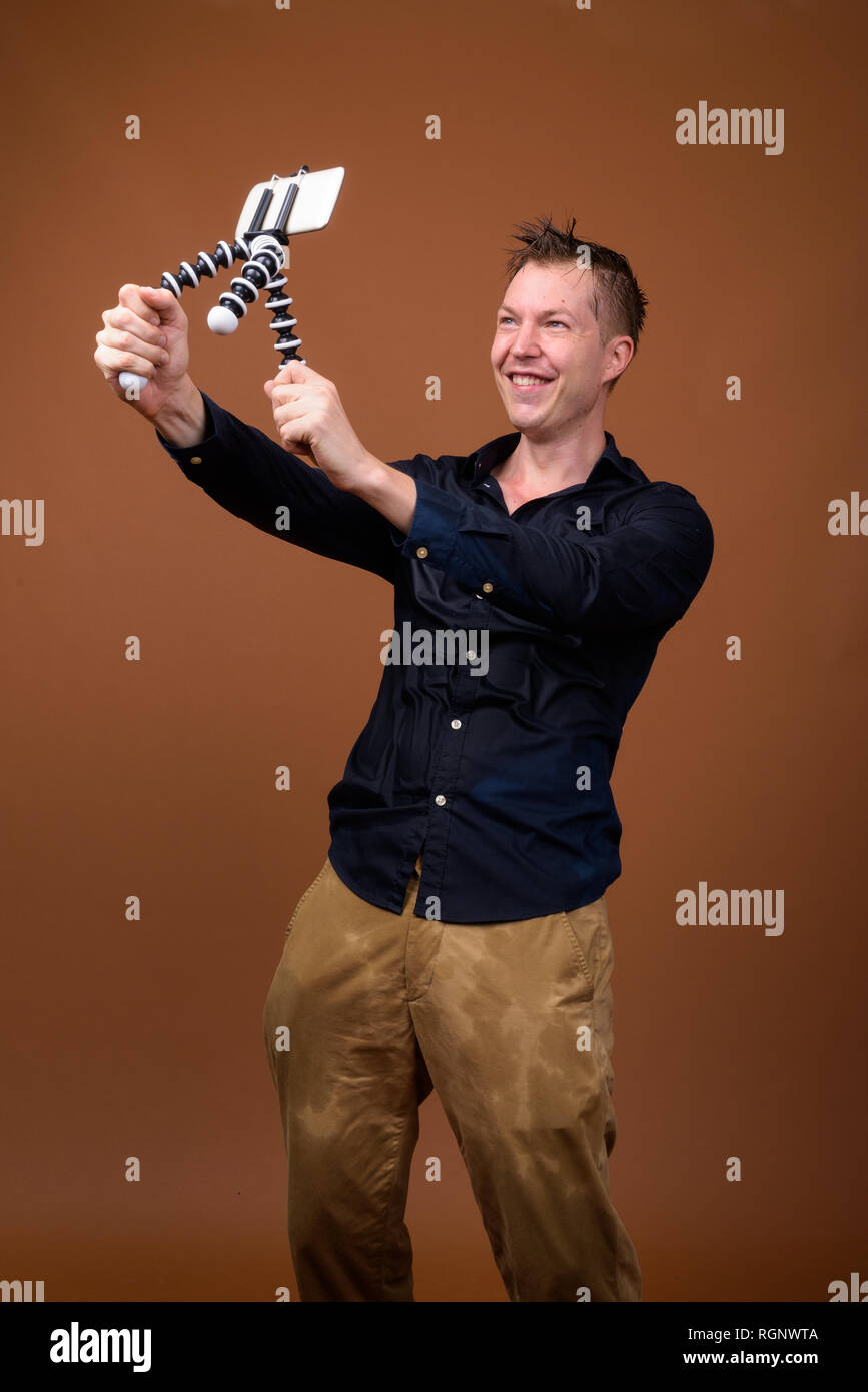 Young man influencer in wet clothes vlogging with mobile phone Stock ...