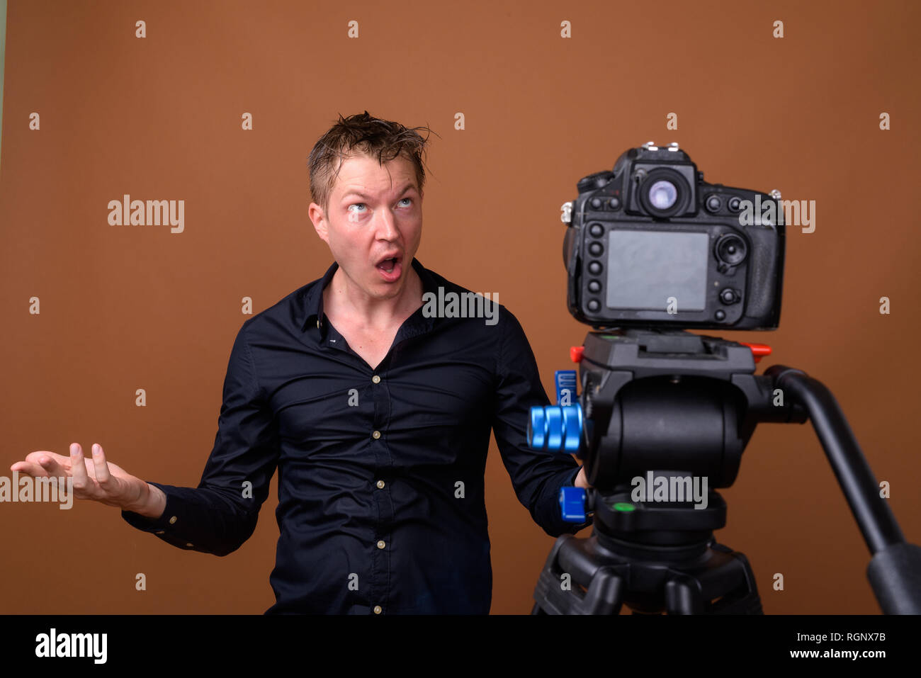 Young man influencer vlogging with DSLR camera in studio while making ...