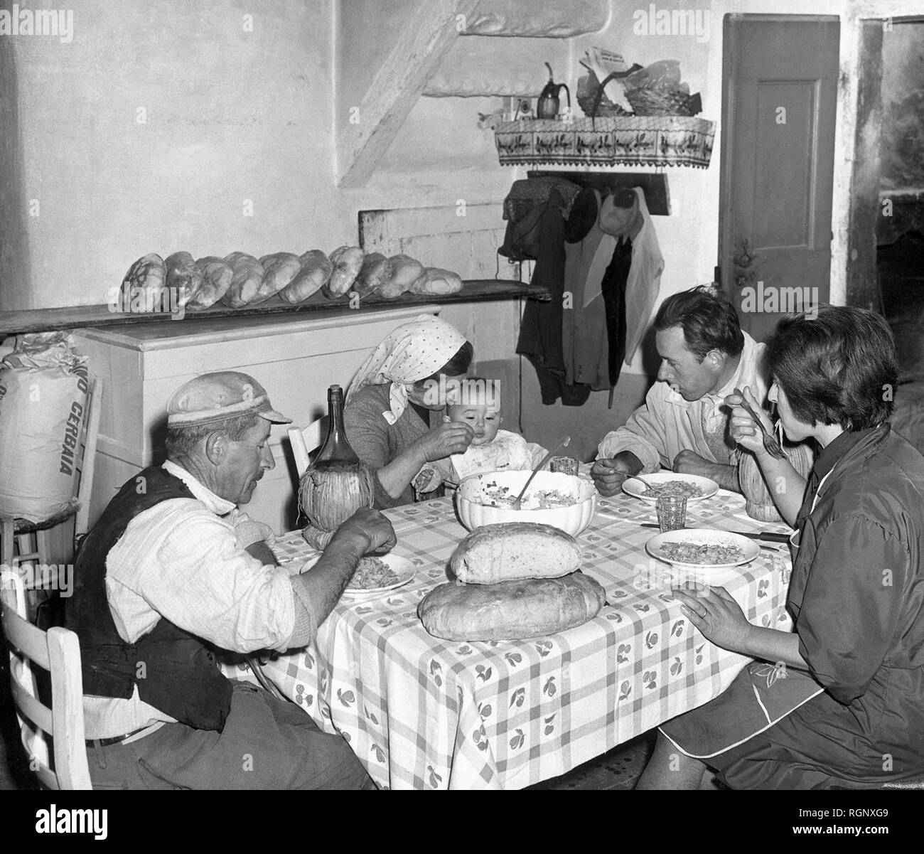 family eating in the back-shop of the bakery, bread on the table, 1967 ...
