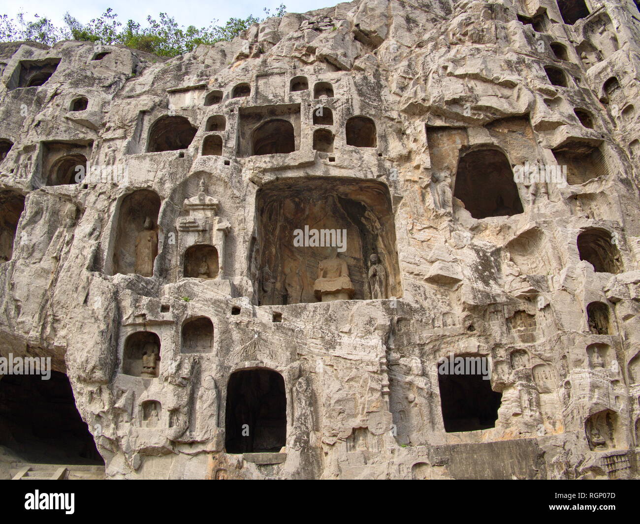Luoyang Longmen grottoes. Broken Buddha and the stone caves and ...