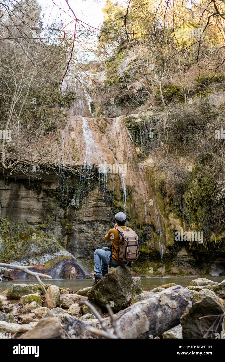 Elegant lady in cap sitting on seat on coast near waving sea Stock ...