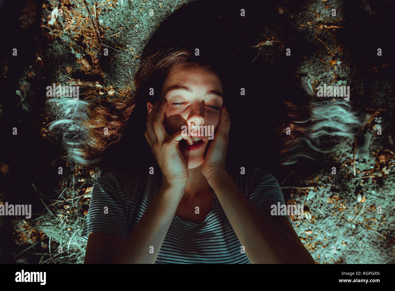 Woman lying on ground Stock Photo - Alamy