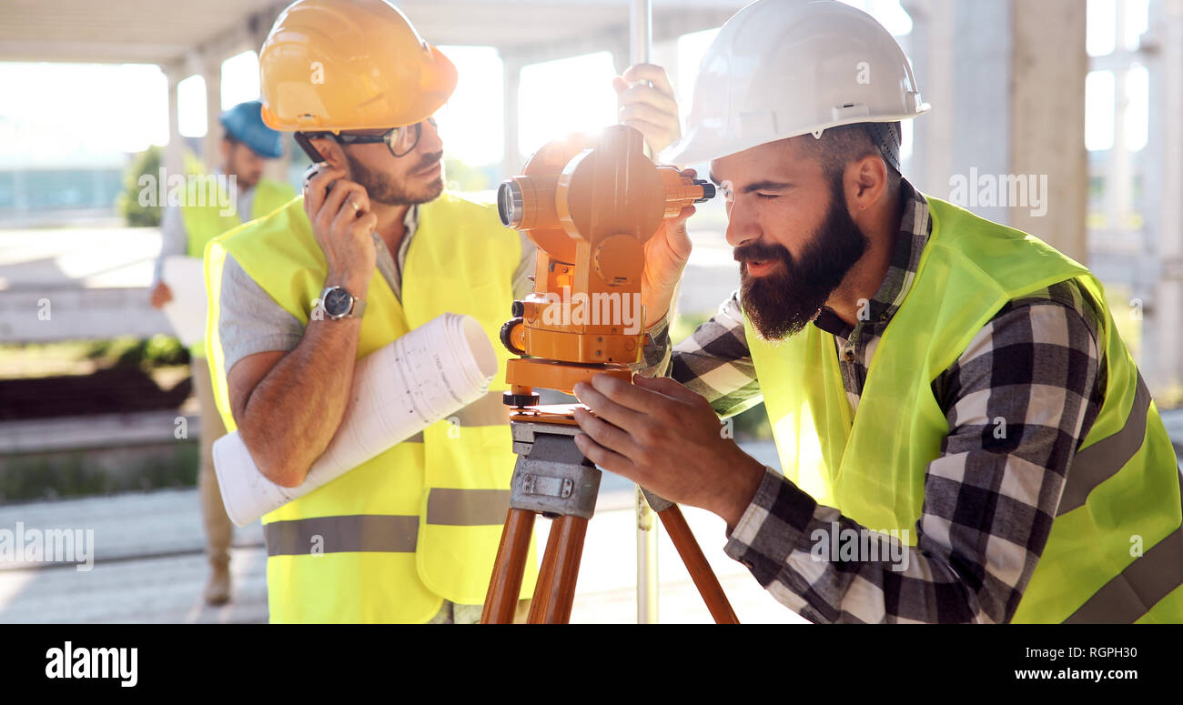 Team of construction engineers working on building site Stock Photo - Alamy