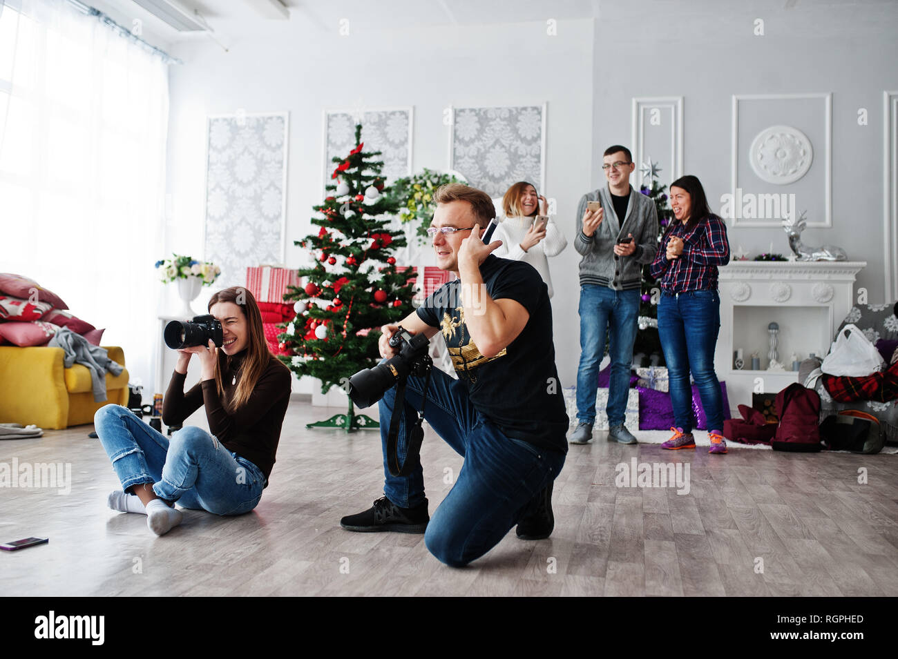 The team of two photographers shooting on studio behind another three ...