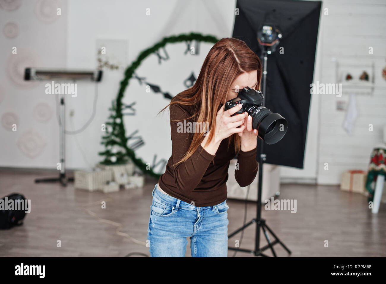 Young girl photographer shooting on studio. Professional photographer ...
