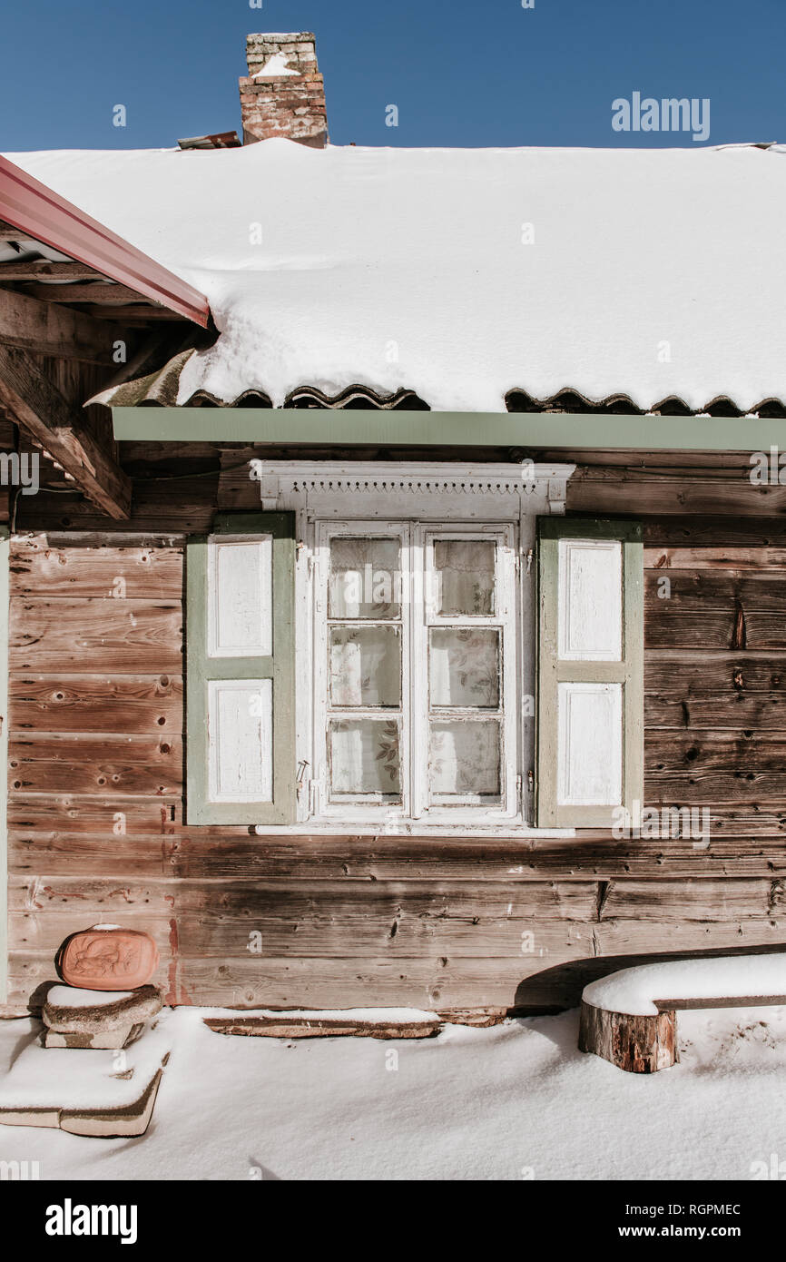 Window of old wooden building in snow in sunny weather in Vilnius ...