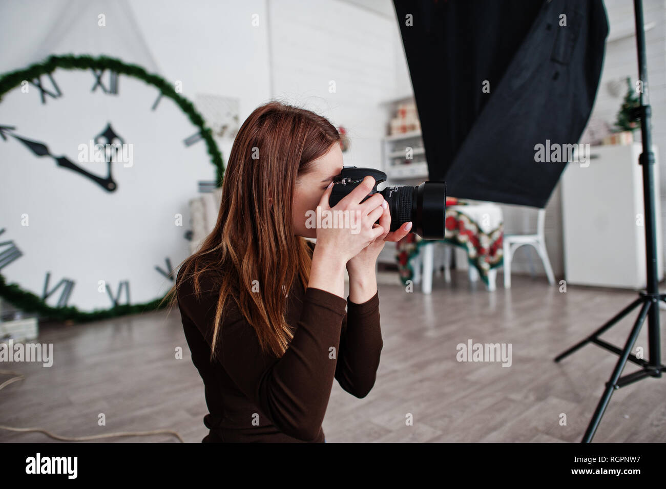 Young girl photographer shooting on studio. Professional photographer on work Stock Photo - Alamy