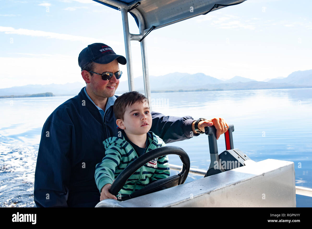 Boy driving a boat on Bathurst Harbour, South West Tasmania, Australia ...