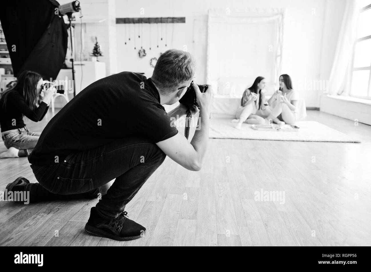 The team of two photographers shooting on studio twins girls ...