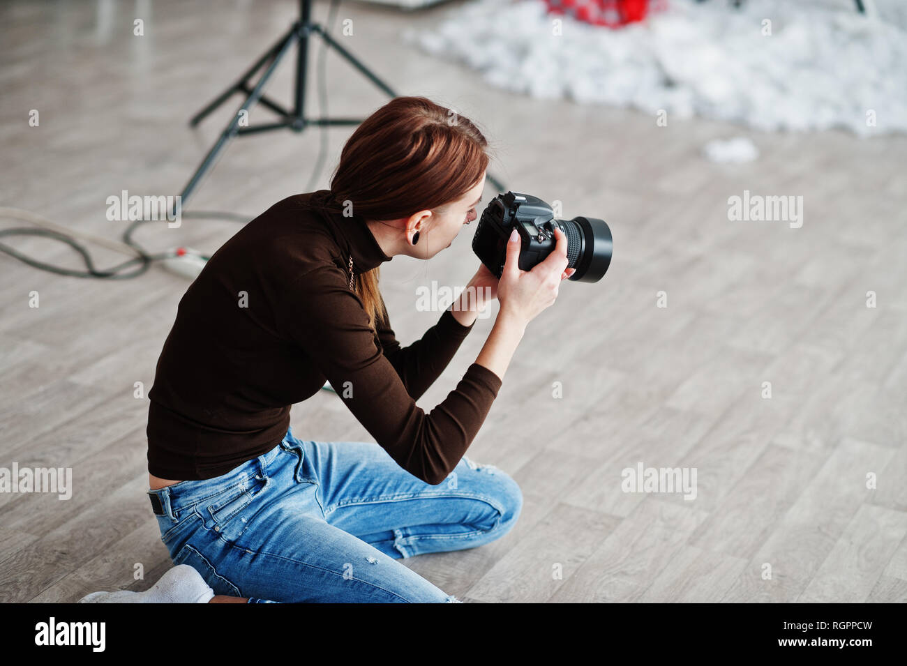 Young girl photographer shooting on studio. Professional photographer ...