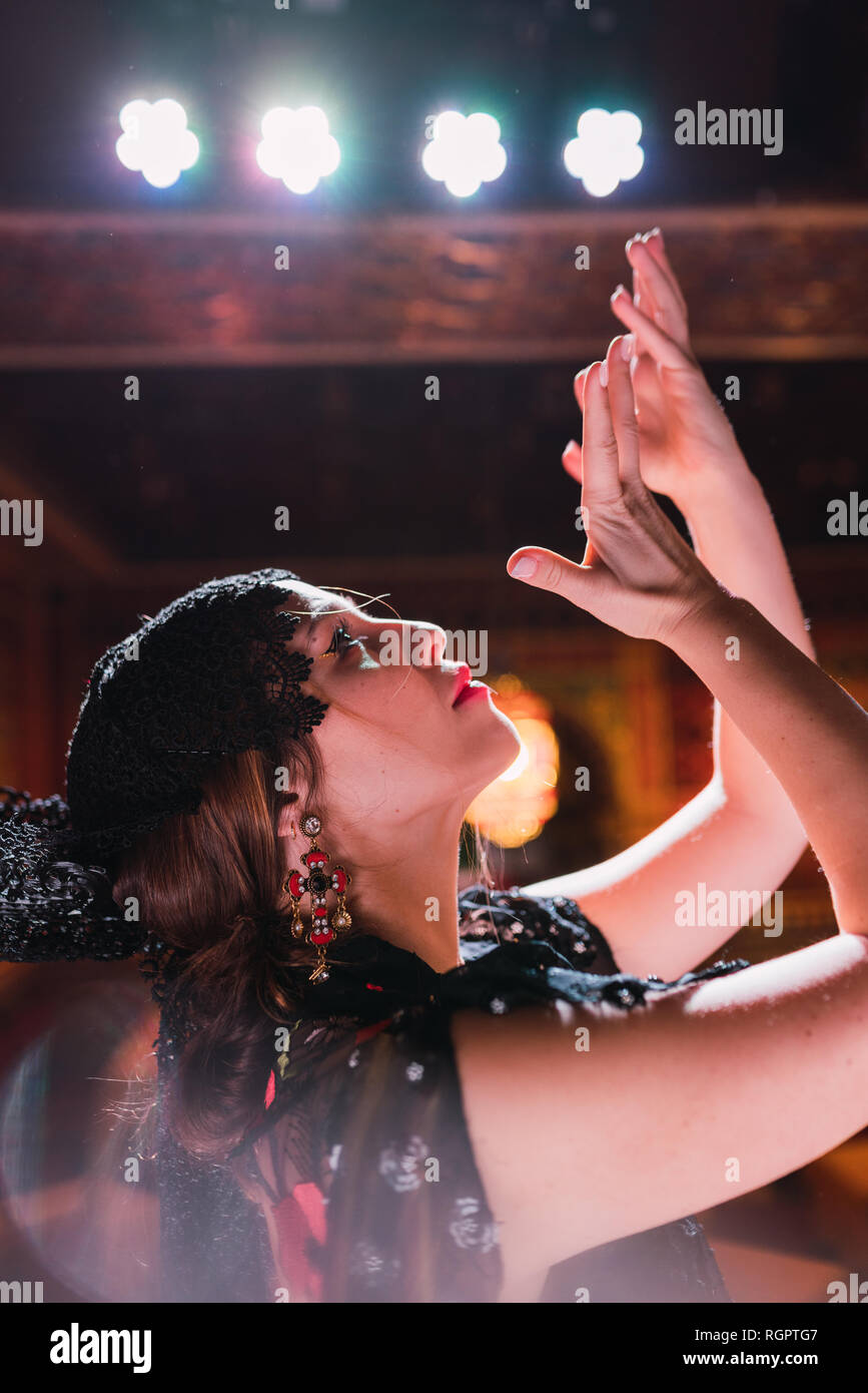 Young lady in dress dancing flamenco on scene in luxury oriental room ...
